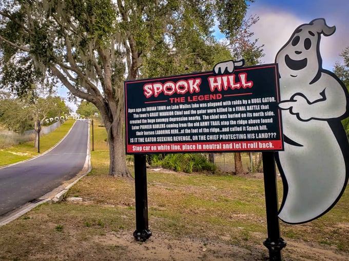 The iconic Spook Hill sign welcomes visitors with its friendly ghost mascot and intriguing legend &ndash; gravity's vacation spot awaits!