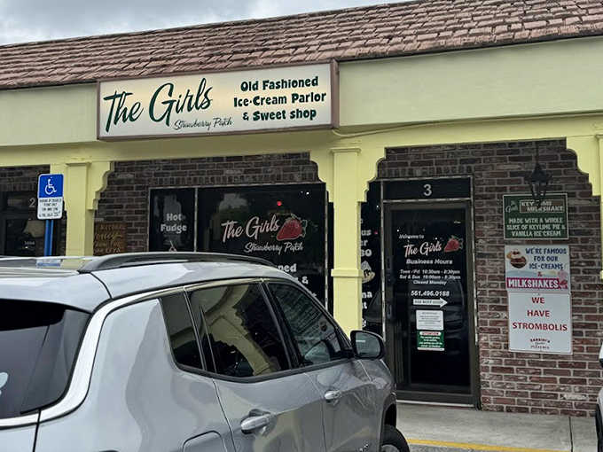 The Girl's Strawberry Patch welcomes visitors with its charming brick facade and vintage signage, promising sweet treats and nostalgic delights inside.
