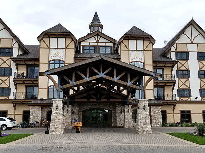 The grand Tudor-style entrance of Avalanche Bay welcomes visitors with its impressive timber frame and stone architecture, promising alpine adventures within.