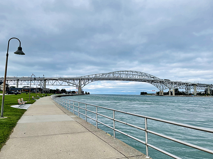 The majestic Blue Water Bridge spans across the St. Clair River, connecting Michigan to Canada while freighters glide beneath its impressive steel arches.