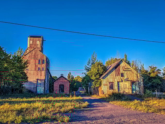 Champion Mine's weathered structures stand like industrial sentinels against Michigan's sky, rust painting them in nature's own palette of oranges and browns.