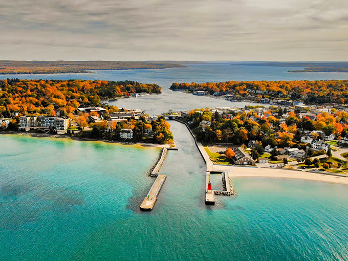 Where turquoise waters meet fiery autumn foliage, creating a postcard-perfect Michigan panorama that defies Midwestern expectations.