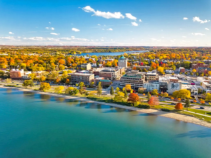 Traverse City's stunning aerial view showcases nature's perfect marriage of azure waters and vibrant autumn foliage &ndash; Michigan's coastal crown jewel.