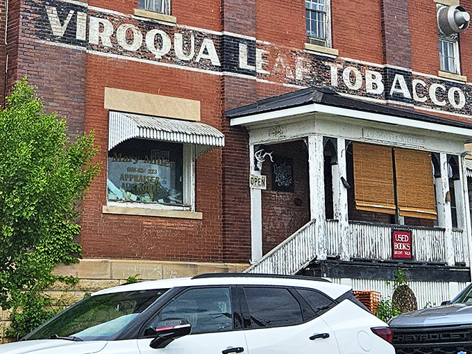 The iconic Viroqua Leaf Tobacco building stands as a brick sentinel, its weathered sign promising literary treasures within.