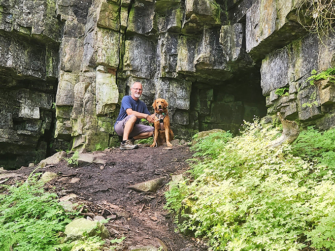 Ancient stone walls embrace visitors at this magical cave entrance, where time seems to stand still among moss-covered rocks.