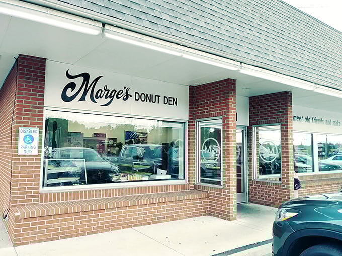 The iconic brick fa&ccedil;ade of Marge's Donut Den welcomes visitors with its vintage charm and promise of sweet treasures within.