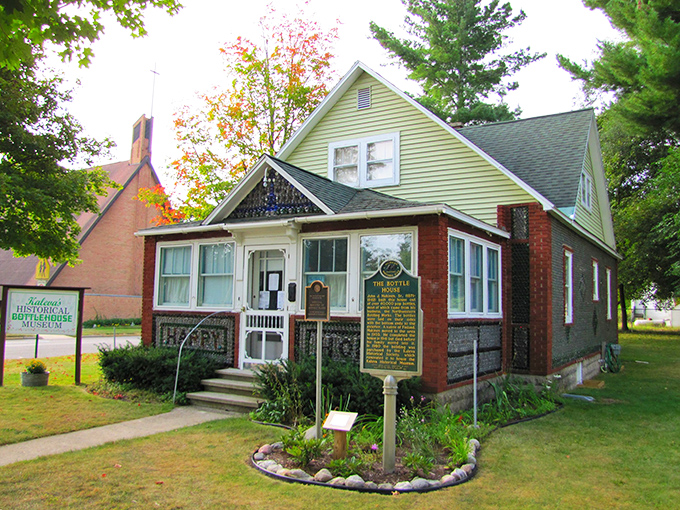 The charming mint-green and brick exterior of Kaleva's Bottle House Museum glows in the afternoon light, thousands of glass bottoms creating a mesmerizing pattern.