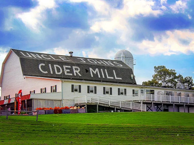 Uncle John's Cider Mill stands proudly against the Michigan sky, its iconic roof sign promising apple-filled adventures for all who visit.