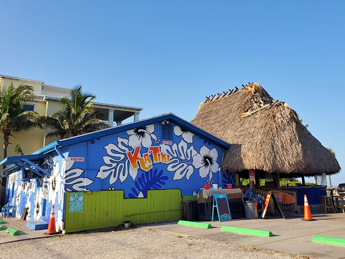 The vibrant blue exterior of Ka'Tiki pops against the Florida sky, its thatched roof promising tropical escape and $3 burger bliss.