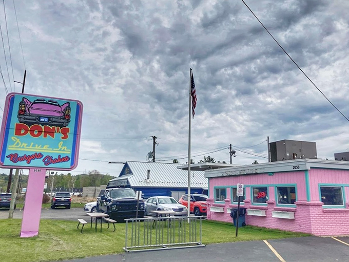 The iconic pink exterior of Don's Drive-In stands out like a retro beacon, promising burgers and nostalgia in equal measure.