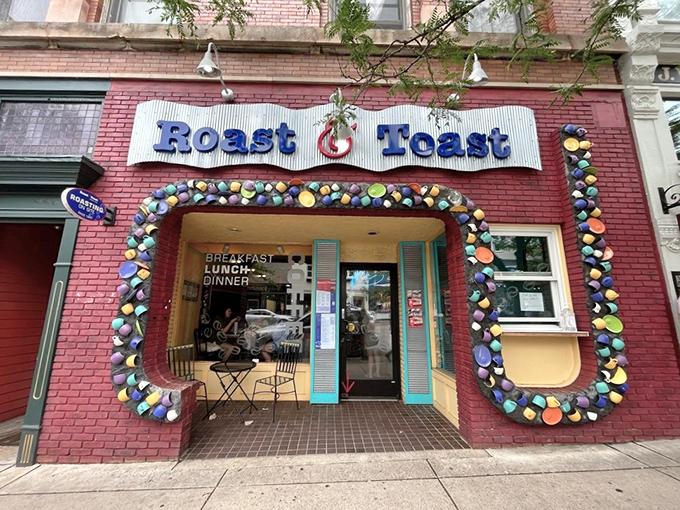 Exterior: The whimsical red brick facade of Roast & Toast, adorned with colorful plates, beckons like a warm hug in downtown Petoskey.