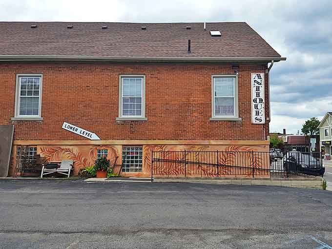 The unassuming brick exterior of Odd Fellows Antiques &ndash; where that modest "LOWER LEVEL" sign points to adventures waiting just beyond the threshold.