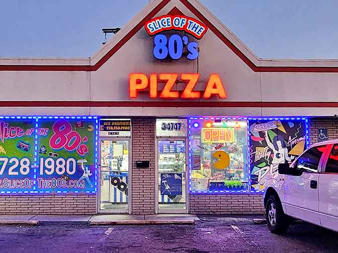 The neon-lit exterior of Slice of the 80s Pizza glows like a beacon for hungry time-travelers, promising both delicious pizza and a radical blast from the past.