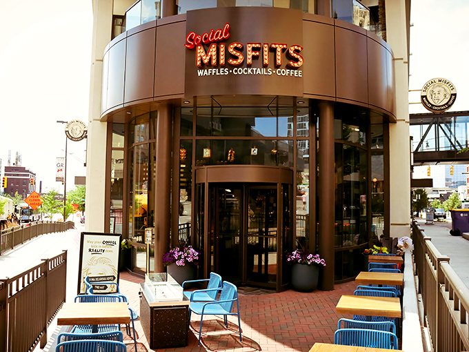 The curved fa&ccedil;ade of Social Misfits glows with invitation, its neon sign promising culinary adventures beyond the ordinary waffle experience.