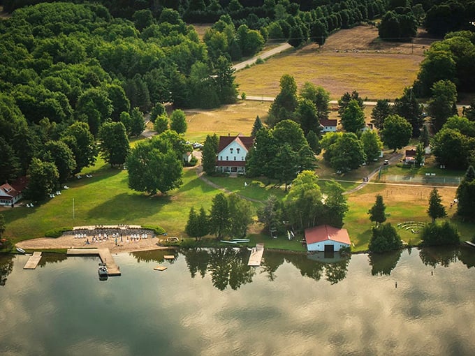 Aerial view of Fountain Point Resort, where the historic white buildings nestle between emerald forests and the sparkling blue waters of Lake Leelanau.