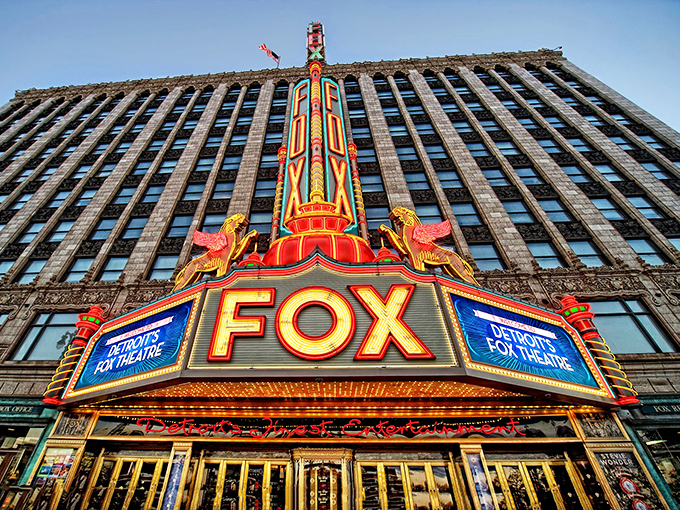 The iconic Fox Theatre marquee blazes against Detroit's skyline, a neon promise of entertainment that's been kept since 1928.