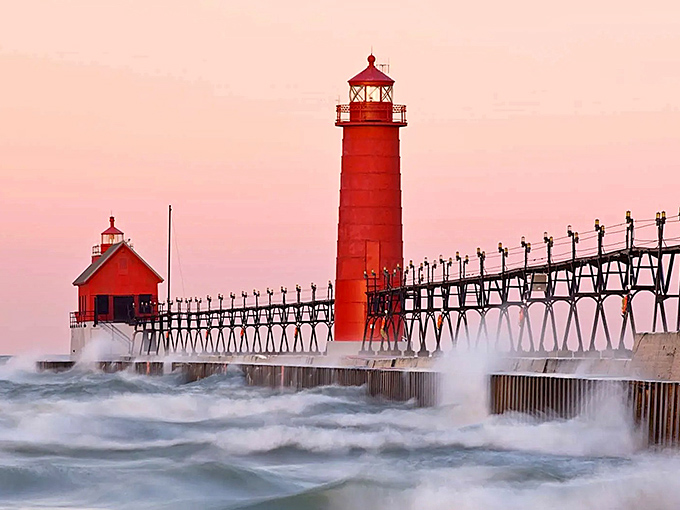Sunset bathes the Grand Haven lighthouse in golden hues, transforming the crimson tower into a fiery sentinel against pastel skies.