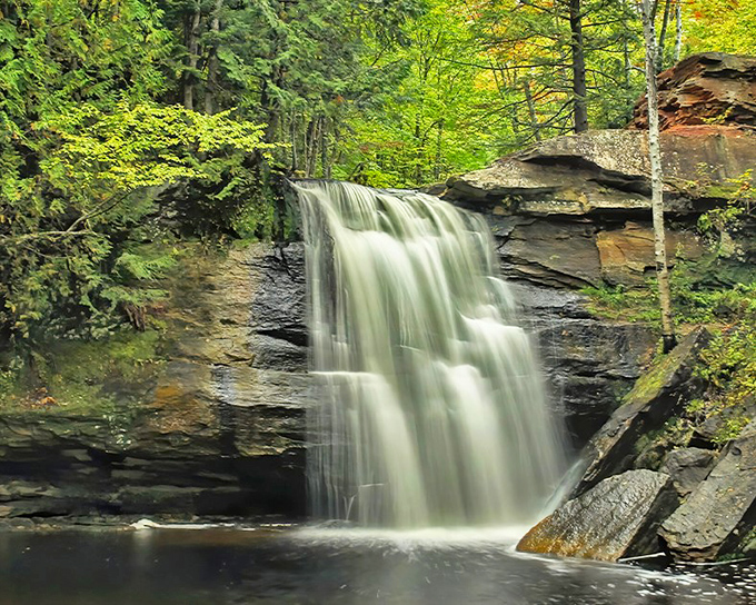 Hungarian Falls cascades with hypnotic grace, a hidden gem where water dances over ancient rock formations in Michigan's secret wilderness.