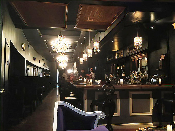 Step into the past at The Oakland, where dark wood paneling and crystal chandeliers create an atmosphere of clandestine luxury reminiscent of Prohibition's finest hideaways.