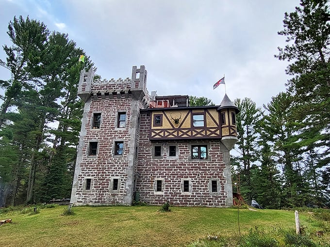 Kelley Castle stands majestically among Wisconsin pines, its stone towers and Tudor-style wing creating a fairytale silhouette against the cloudy sky.