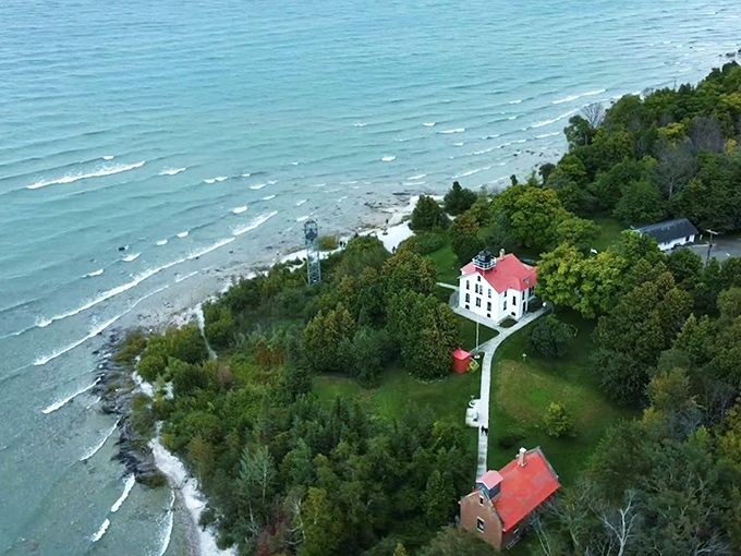 A bird's-eye view of paradise where the white lighthouse stands guard over turquoise waters and emerald forests.