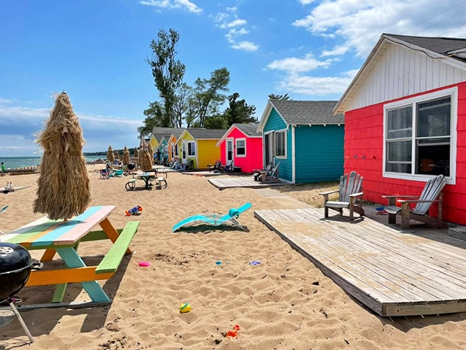 A rainbow of beach cottages lines the sandy shore, each one a tiny tropical escape from everyday life.