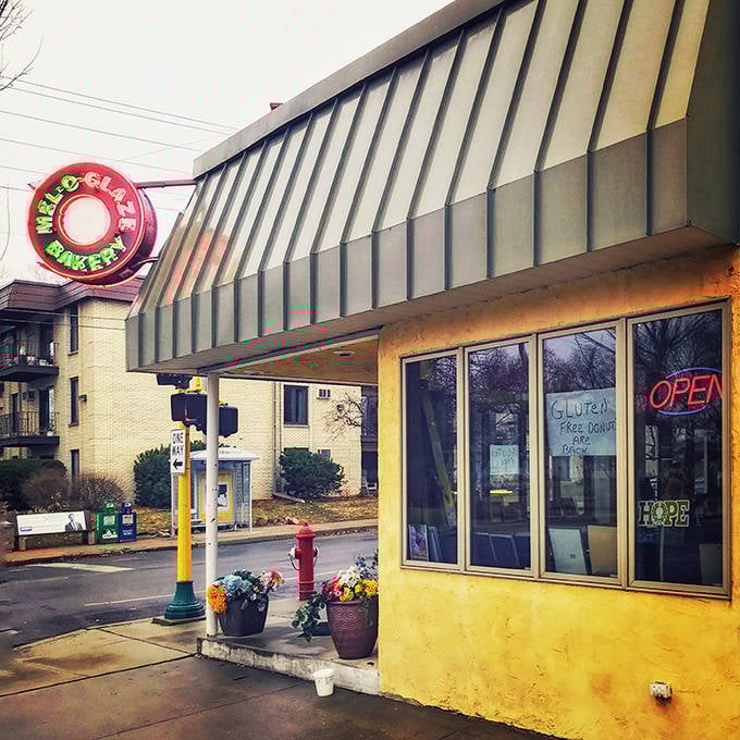 The cheerful yellow exterior of Mel-O-Glaze beckons with its vintage neon sign – a beacon of sweetness on a Minneapolis corner.