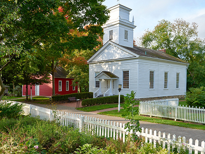 The pristine white church at Mill Race Historical Village stands as a beacon of 19th-century architecture, its steeple reaching skyward like a historical exclamation point.