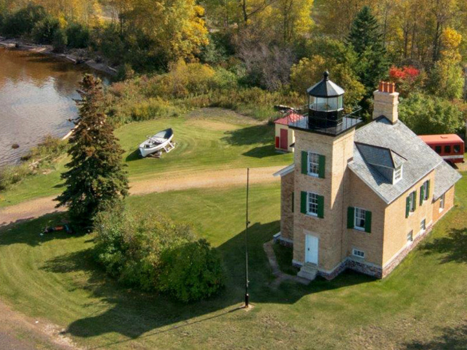 Ontonagon Lighthouse stands proudly against autumn foliage, its honey-colored bricks glowing in the Michigan sunshine like a warm welcome home.