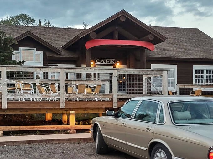 Rustic Inn Cafe welcomes hungry travelers with its charming timber facade and inviting red awning—a woodland oasis for food lovers.