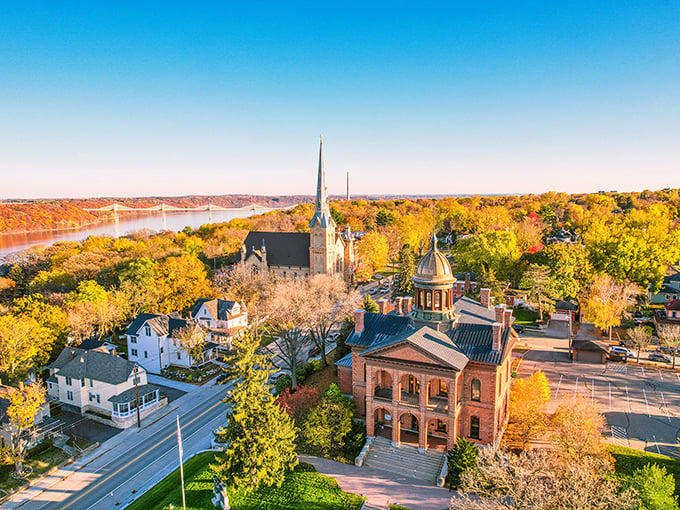 Stillwater's historic skyline glows in autumn gold, church spires reaching skyward while the mighty St. Croix River winds peacefully below.
