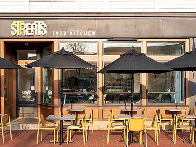 The inviting storefront of Streats Taco Kitchen beckons with its sleek design and cheerful yellow outdoor seating &ndash; taco paradise awaits!