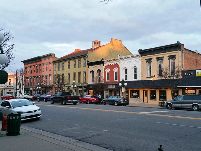 Downtown Tecumseh's historic facades glow in golden hour light, brick buildings standing proud like they've got stories bursting to tell.