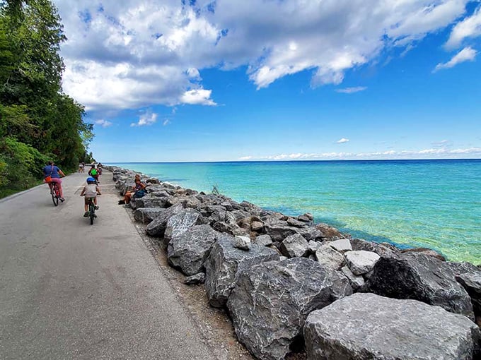 Cyclists glide along Mackinac Island's shoreline path where impossibly blue waters meet the sky &ndash; nature's perfect backdrop for two-wheeled adventures.