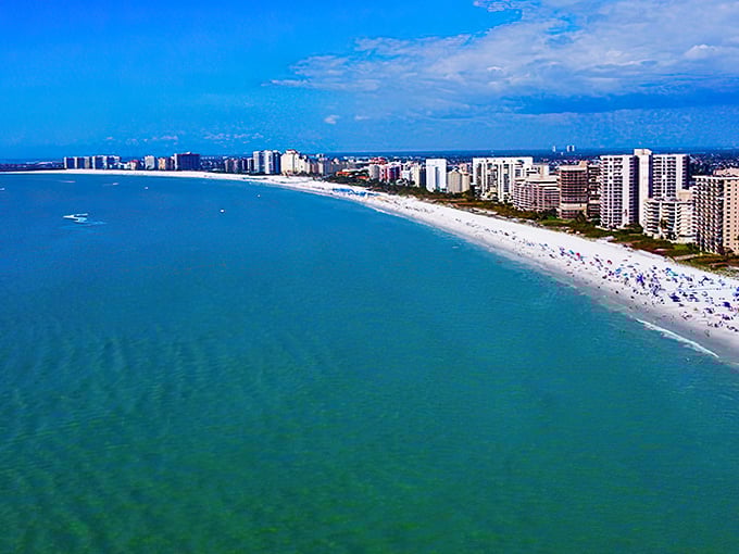 Marco Beach's sweeping shoreline curves like nature's smile, with high-rises standing at attention against the endless blue horizon.