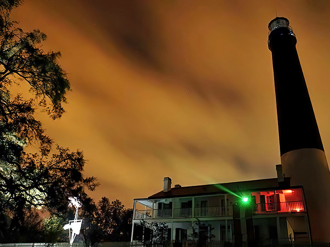 The Pensacola Lighthouse stands majestically against an amber sky, its black and white spiral a dramatic exclamation point on Florida's Gulf Coast.
