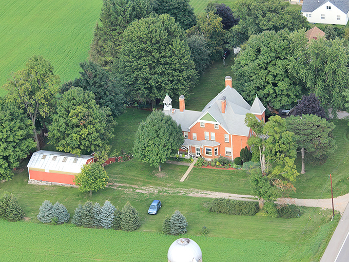 Aerial view of The Brickhouse of Somerset, a stately Victorian mansion surrounded by lush greenery and farmland &ndash; history standing proudly amid modern times.