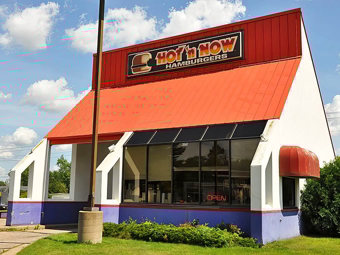 The iconic red-roofed Hot 'n Now stands like a beacon of burger hope in Sturgis, Michigan, its distinctive architecture a nostalgic nod to simpler times.