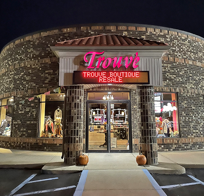 The glowing pink sign of Trouv&eacute; Boutique Resale lights up the night, beckoning fashion hunters like moths to a stylish flame.
