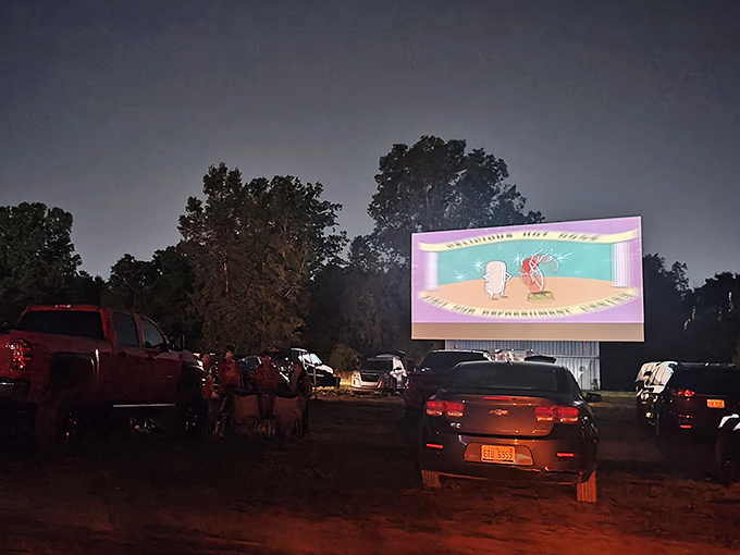 Twilight magic at the US 23 Drive-In Theater, where classic cartoons dance across the massive screen as cars settle in for showtime.