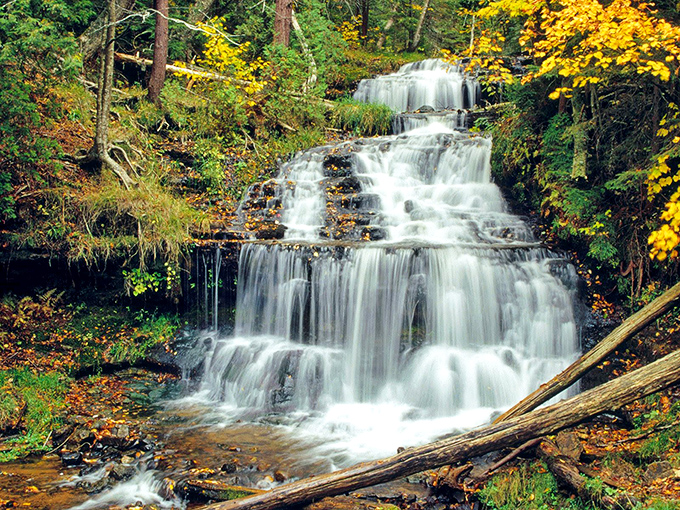 Wagner Falls cascades gracefully through Michigan's lush forest, creating a multi-tiered spectacle that captivates visitors year-round.