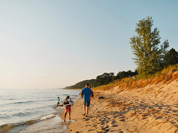 A family strolls along the golden shoreline of Windsnest Park, where footprints in the sand tell stories of perfect summer days.