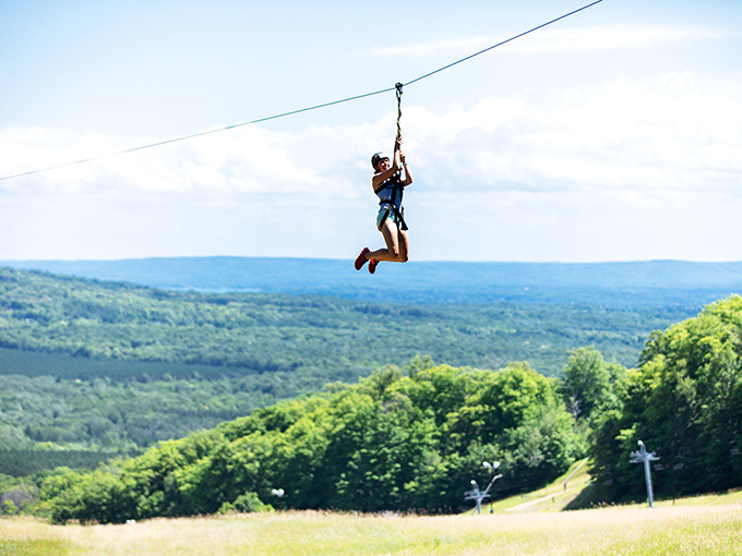 Soaring through the sky, this zipline adventurer experiences Michigan's landscape from a thrilling new perspective. Freedom with a safety harness!