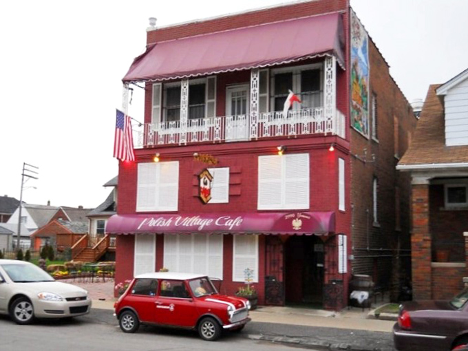 The vibrant red exterior of Polish Village Cafe stands out in Hamtramck like a beacon of culinary tradition, complete with vintage signage and classic Mini Cooper parked out front.