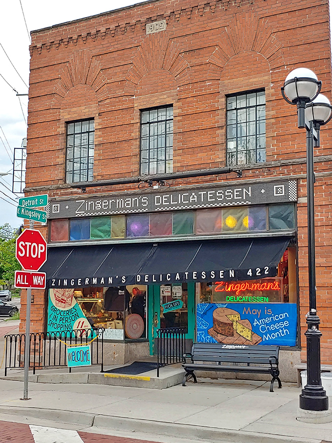 A historic brick building with colorful stained glass welcomes visitors to Zingerman's Delicatessen, where culinary adventures begin at the corner of Detroit and Kingsley.