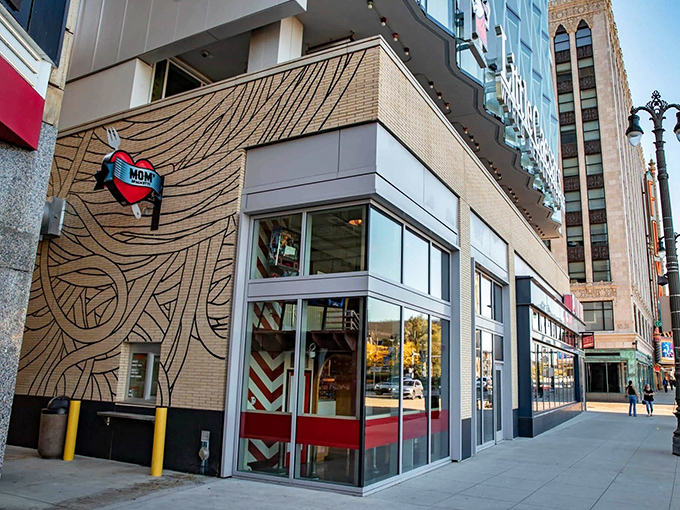 The distinctive wood-grain exterior of Mom's Spaghetti beckons pasta lovers with its heart-shaped logo, standing out boldly against Detroit's downtown landscape.