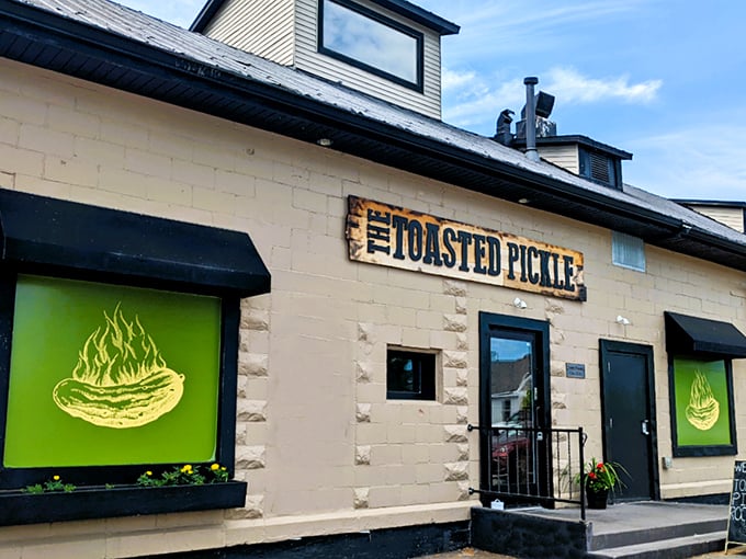 The Toasted Pickle's inviting exterior beckons with vibrant green windows and rustic charm, promising pickle paradise within Rockford's dining scene.