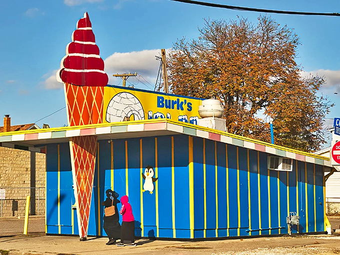 The iconic blue building with its towering red cone sculpture stands like a beacon of summer joy against Michigan's blue sky.