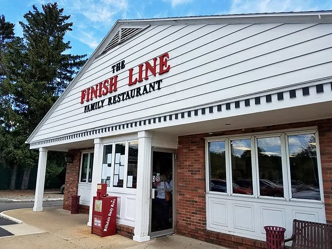 The Finish Line Family Restaurant welcomes hungry patrons with its distinctive white siding and bold red lettering &ndash; a checkered flag for your appetite!