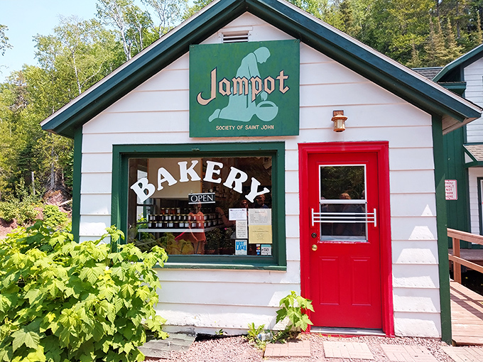The charming exterior of Jampot Bakery beckons with its bright red door and simple "BAKERY" sign &ndash; a humble gateway to extraordinary treats.